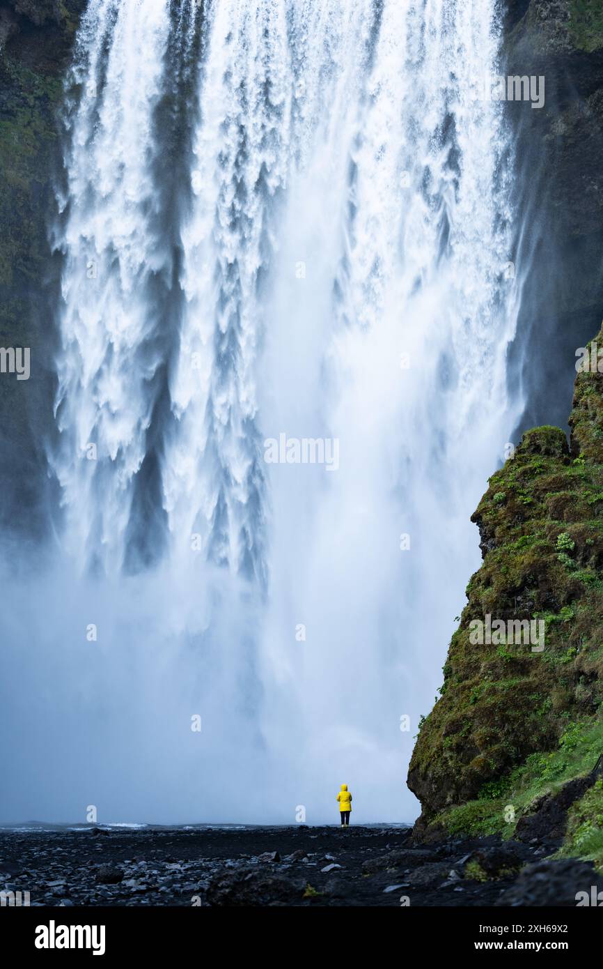 Stunning view of the Skógafoss Waterfall with a tourist wearing a ...