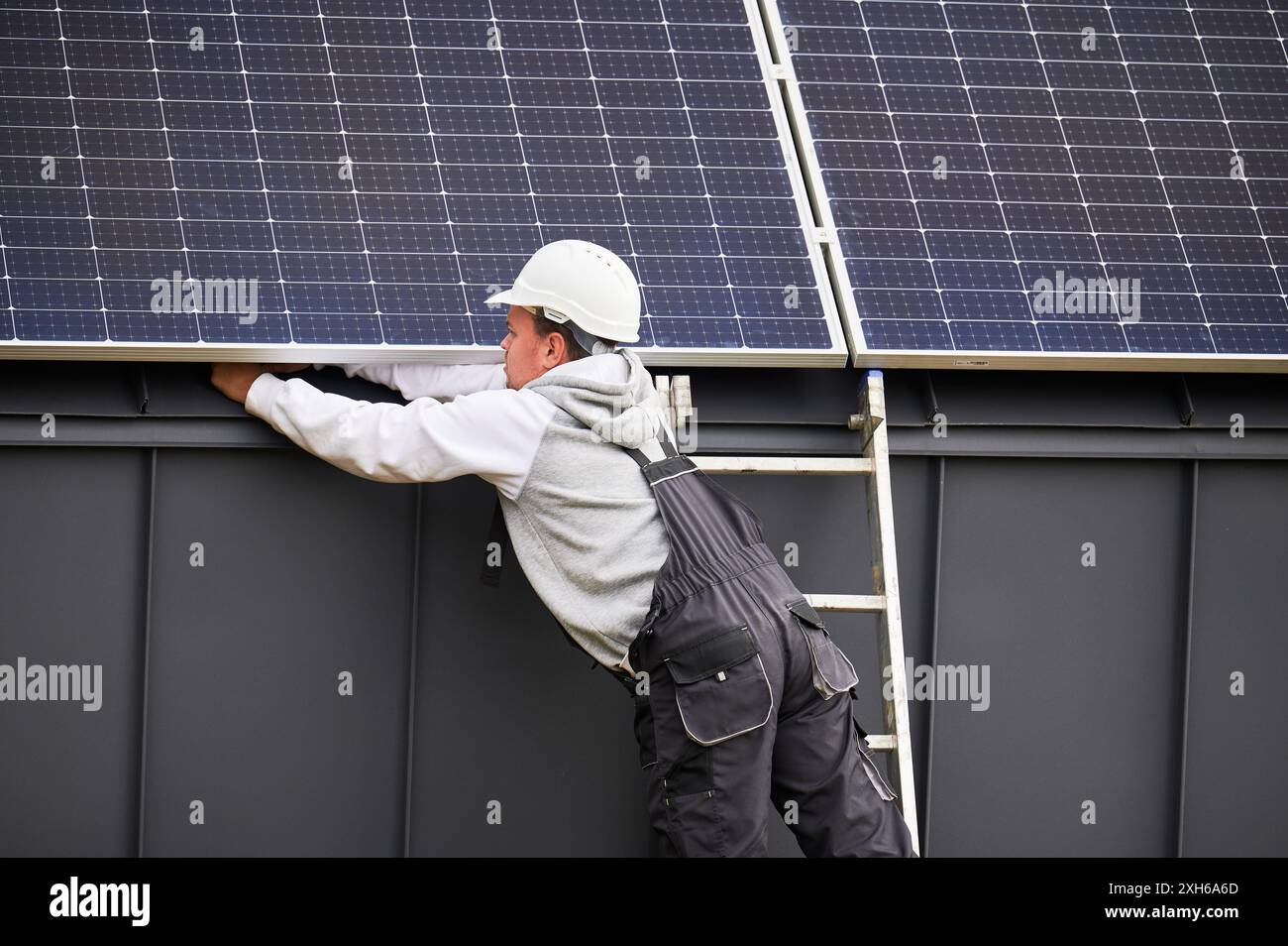 Electrician connecting cables while installing photovoltaic solar ...