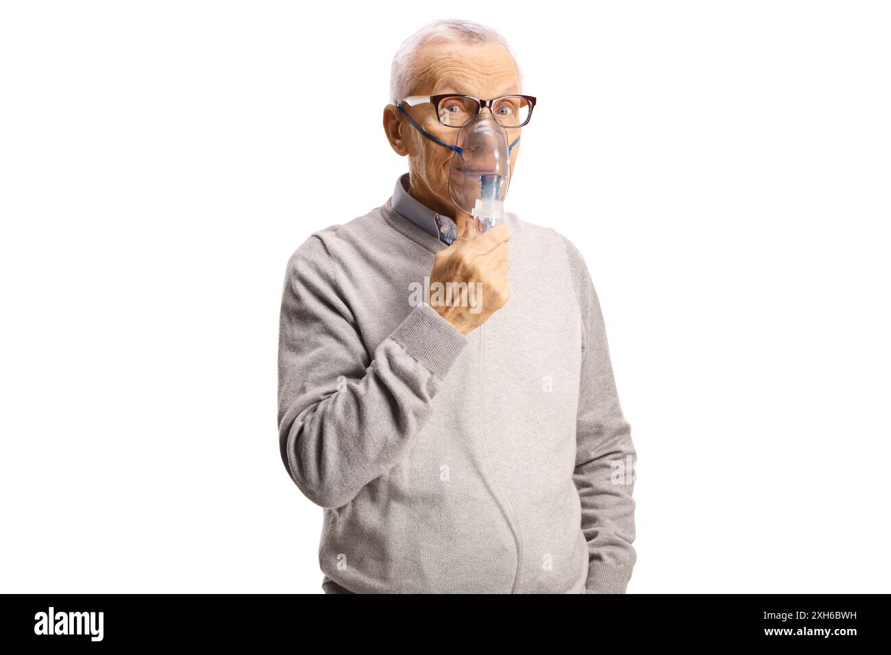 Elderly man using inhaling mask from a nebulizer isolated on white ...