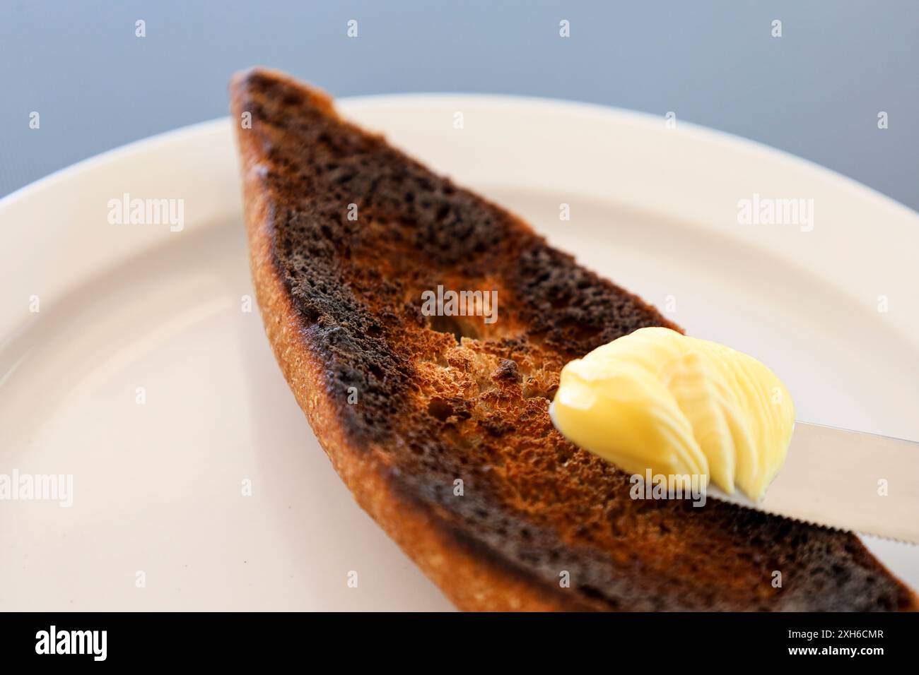 Burnt toast whole wheat and knife spreading butter Stock Photo - Alamy
