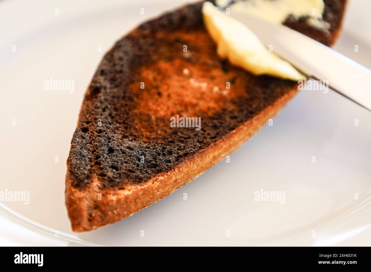 Burnt toast whole wheat and knife spreading butter Stock Photo - Alamy