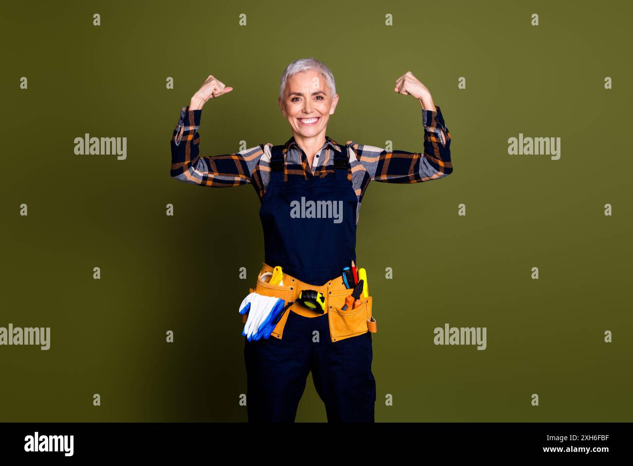 Photo of attractive mature woman professional mechanic show muscles ...