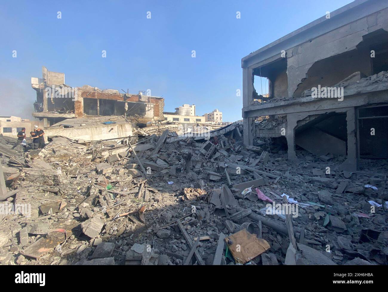 People walk on rubble as they inspect the damage UN Relief and Works ...
