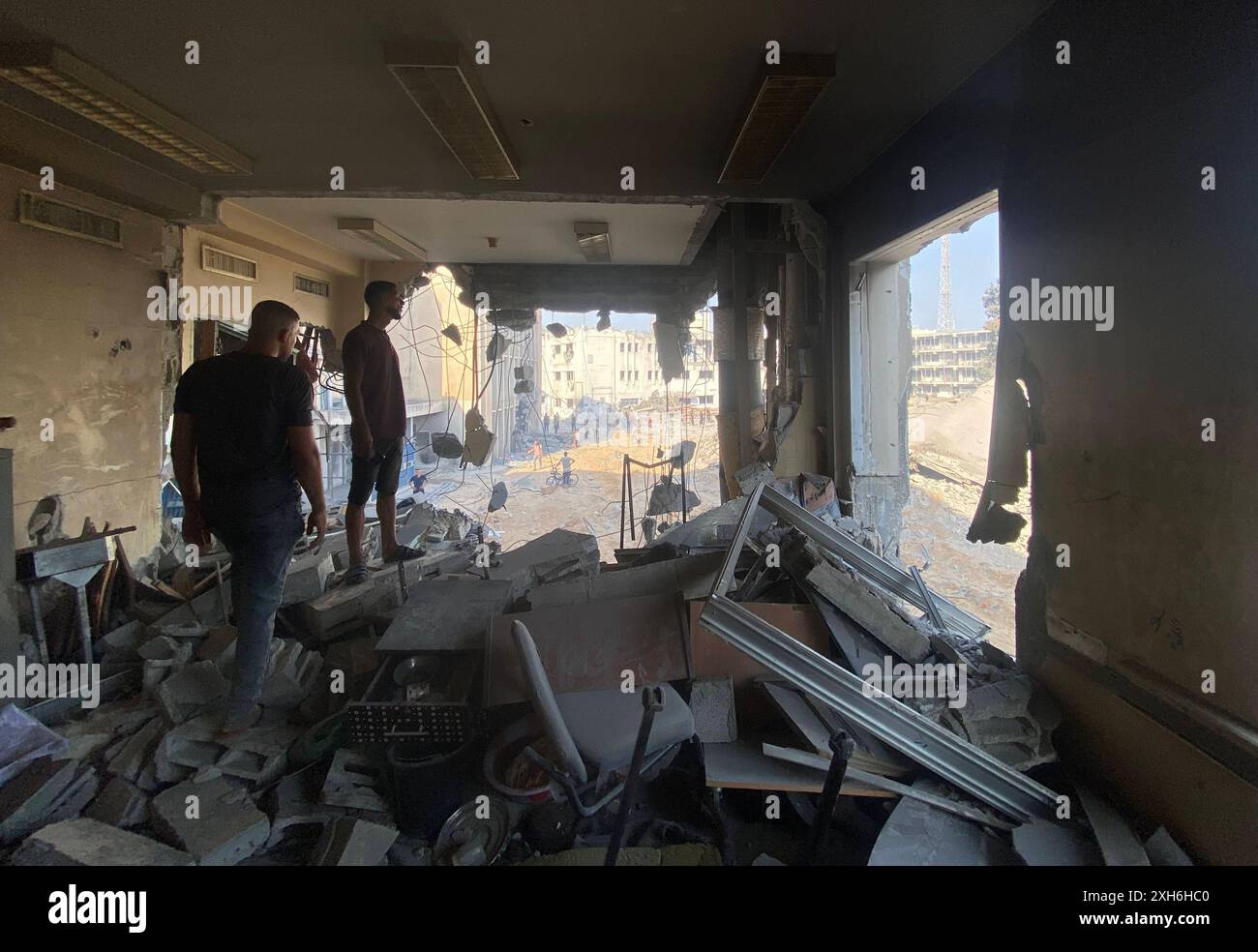 People walk on rubble as they inspect the damage UN Relief and Works ...
