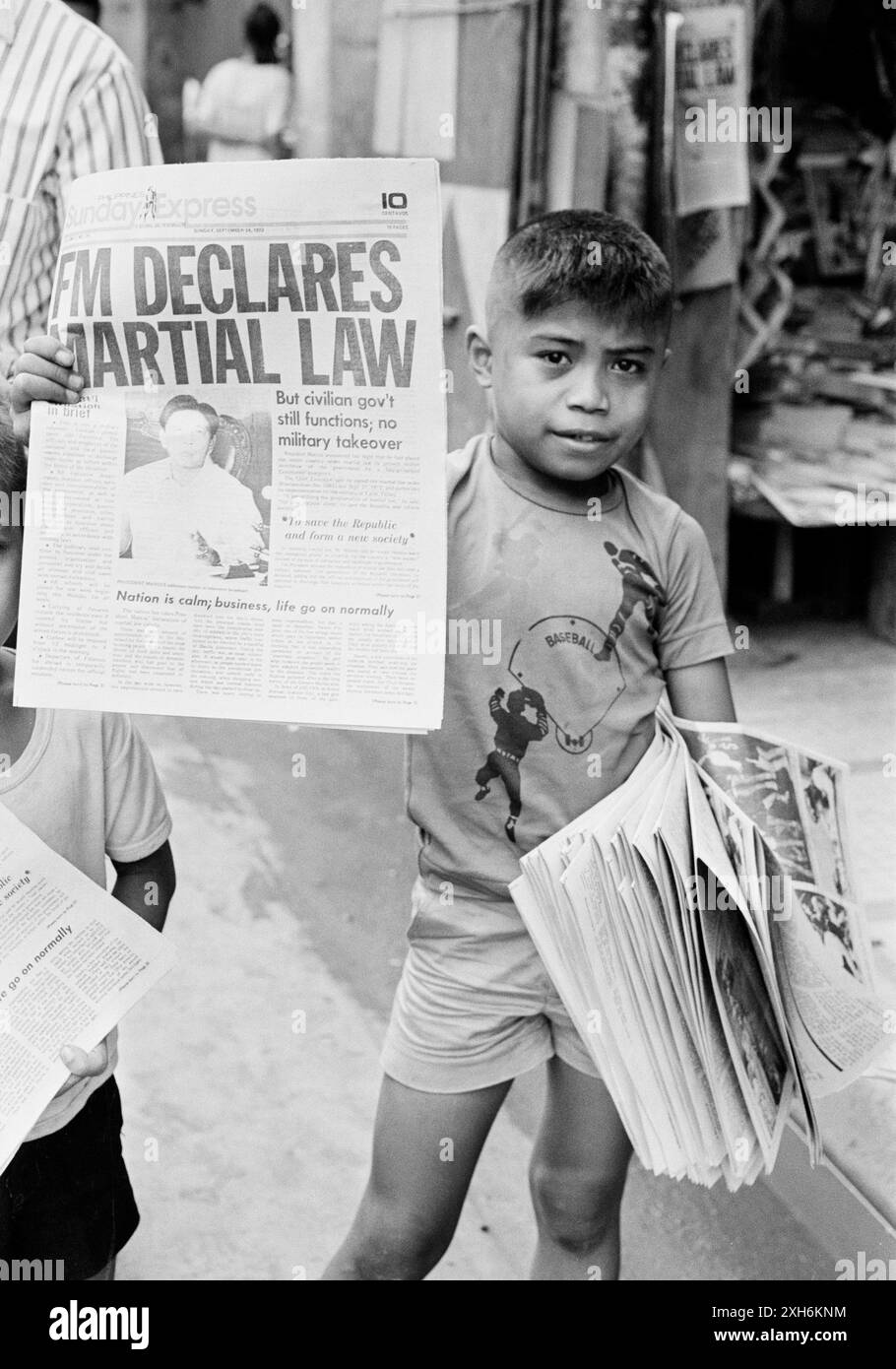 A Filipino newsboy waves a copy of the Philippines Daily Express, Sept ...