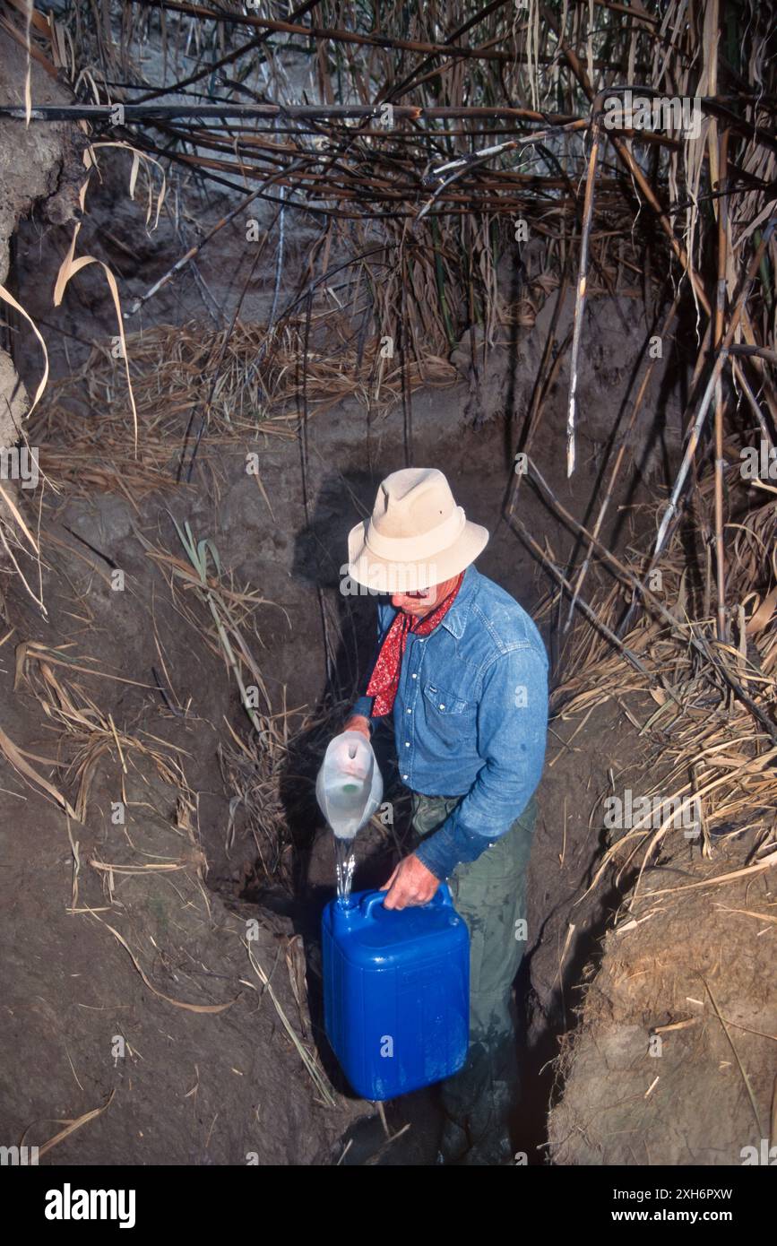 Canoeist filling water container, hot springs at Rio Grande, The Lower ...