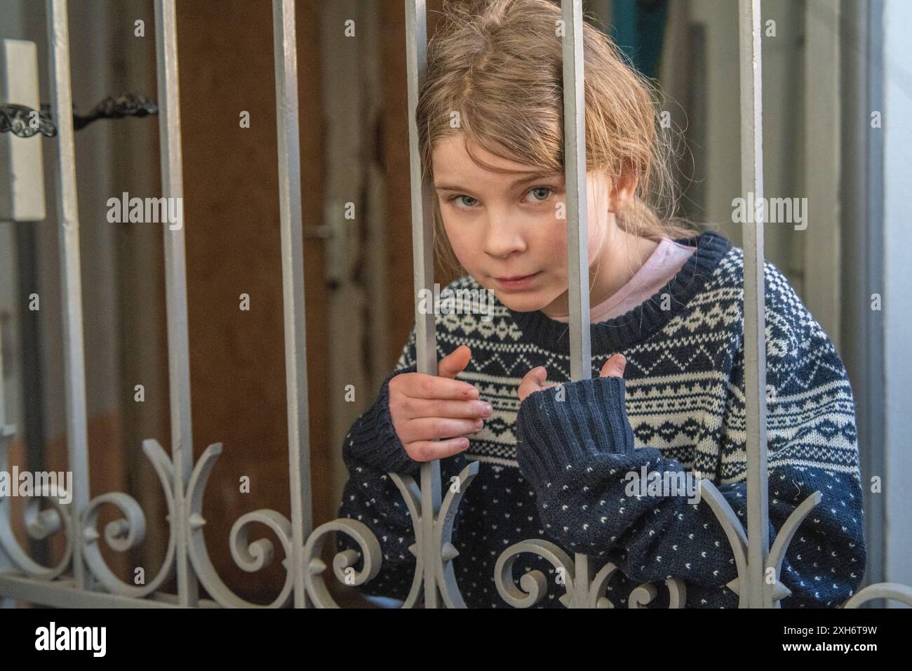 Ostracized: The young pretty girl looks sadly through a closed door ...