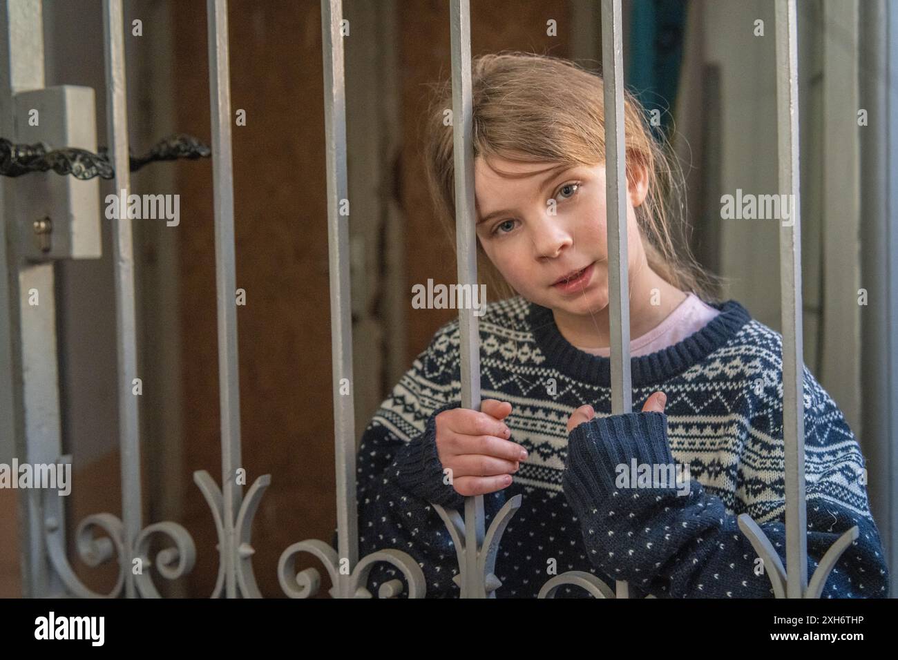 Ostracized: The young pretty girl looks sadly through a closed door ...