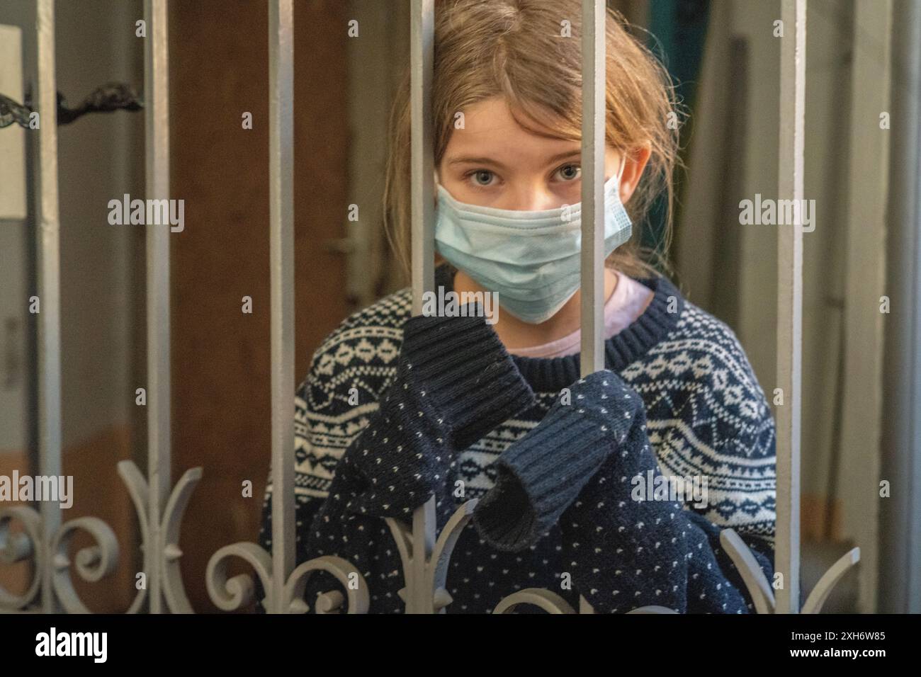 Ostracized: The young pretty girl looks sadly through a closed door ...