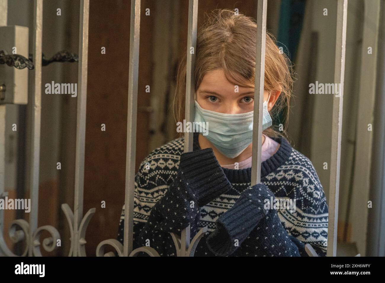 Ostracized: The young pretty girl looks sadly through a closed door ...