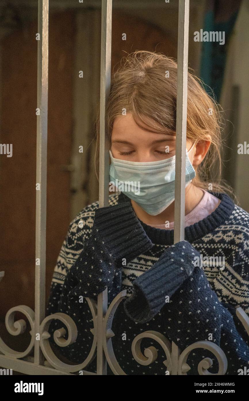 Ostracized: The young pretty girl looks sadly through a closed door ...