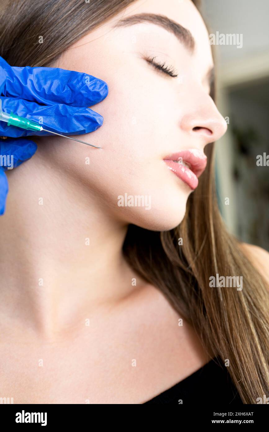 Woman getting cosmetic injection of botox in cheek, closeup. Woman in ...