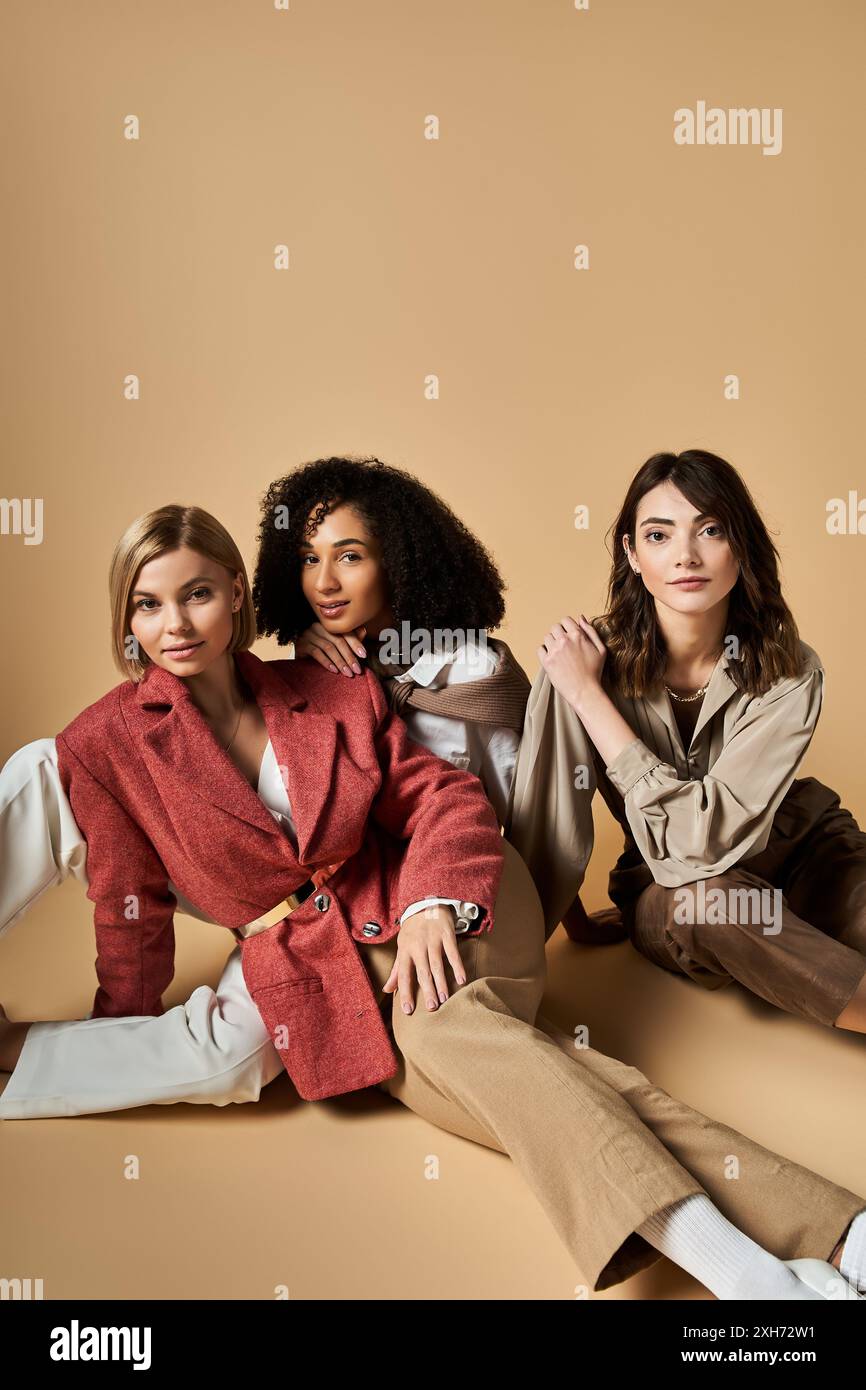 Three young women from diverse cultures in stylish attire sitting on ...