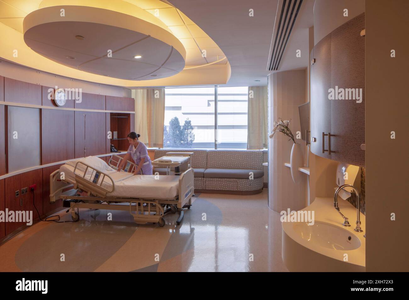 Private room with light feature and a nurse preparing the bed. Danat Al ...