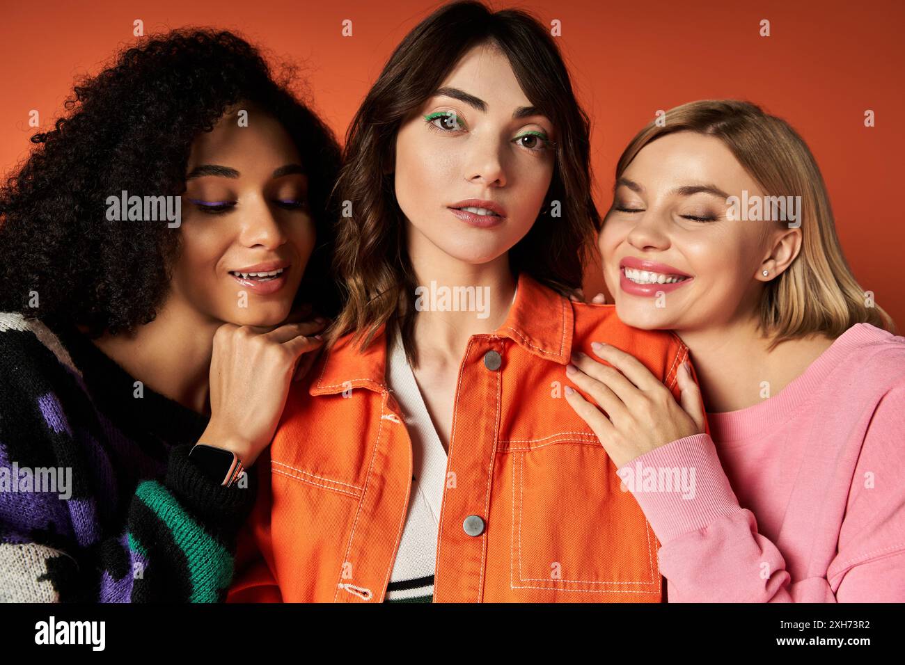 Three young, beautiful women in stylish, vibrant clothing striking a ...