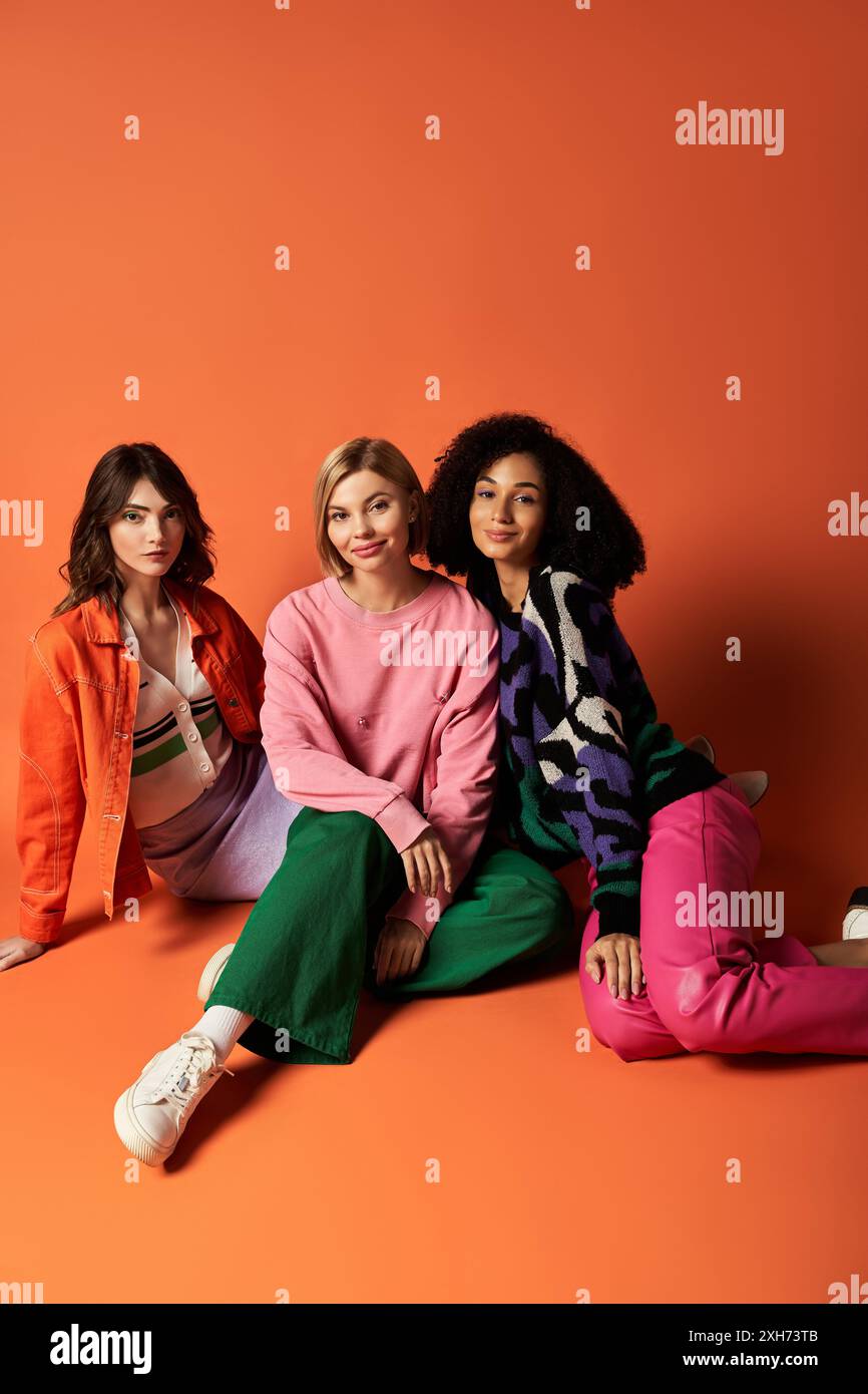 Young, beautiful women in stylish clothes sit together, showcasing ...