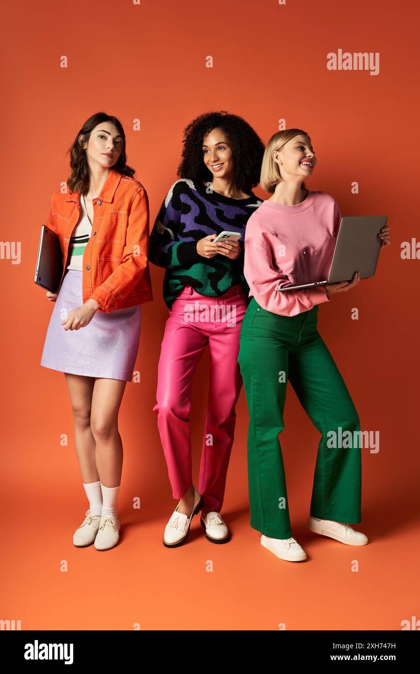 Three young women, diverse in culture, pose in stylish clothes against ...