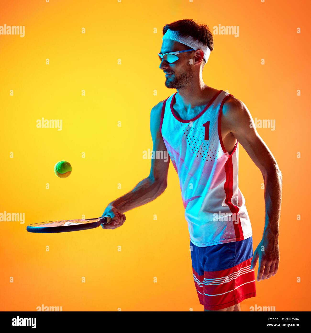 Man in sportswear and sunglasses playing beach tennis, holding padel ...