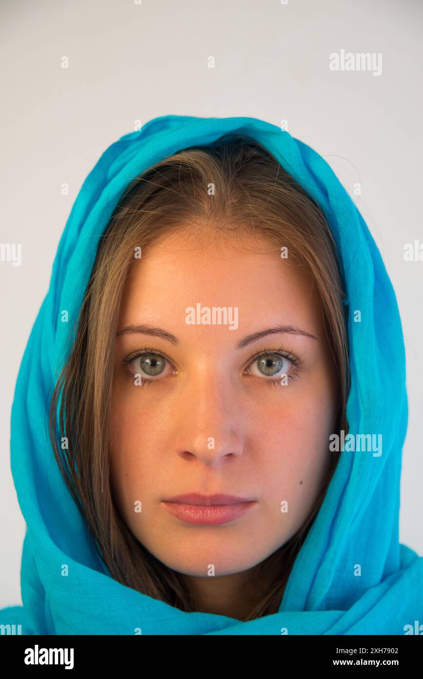 Portrait of blonde young woman wearing turquoise shawl Stock Photo - Alamy