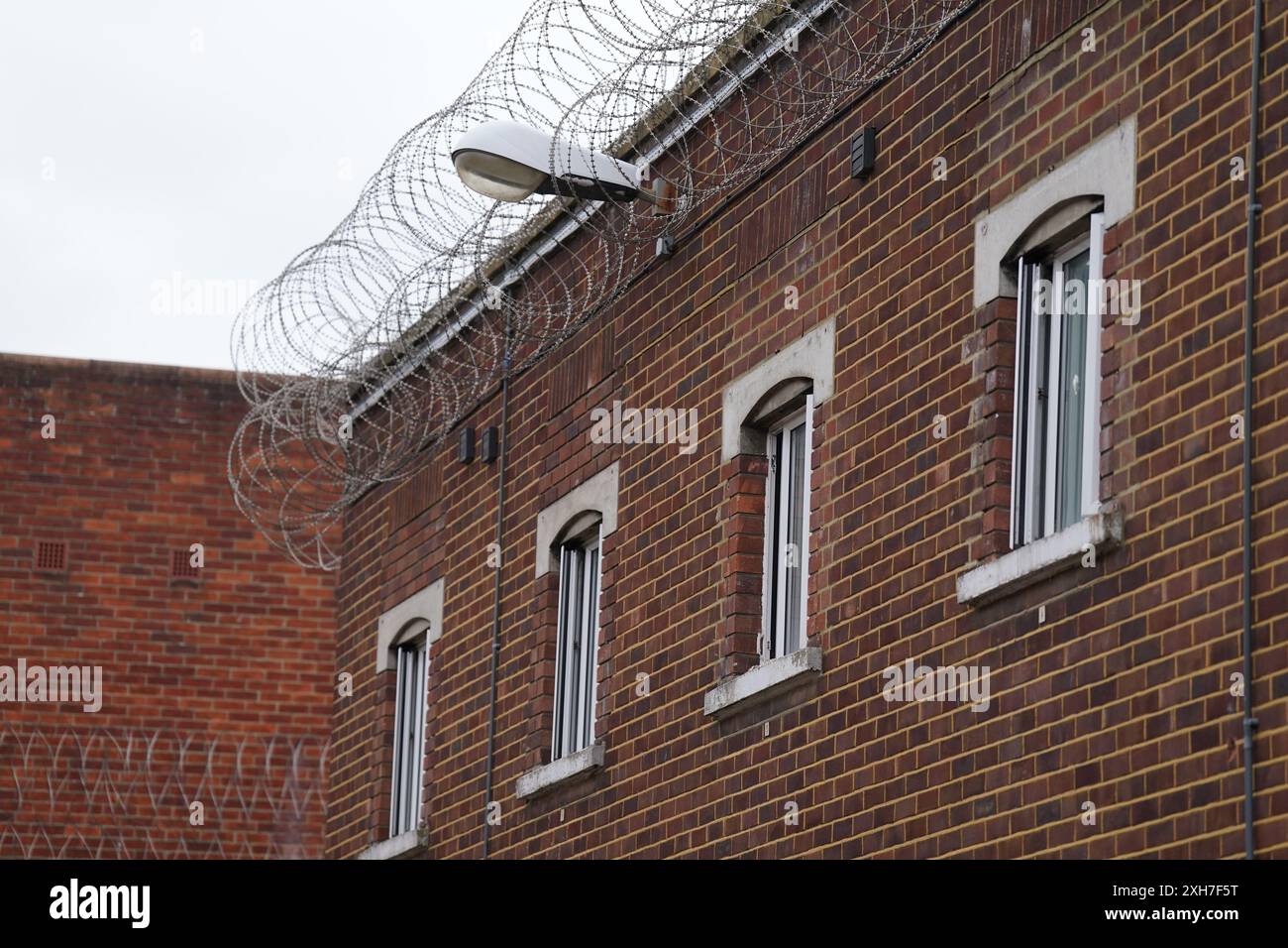 Barbed wire and windows to cells on the walls of HMP Bedford in Harpur ...