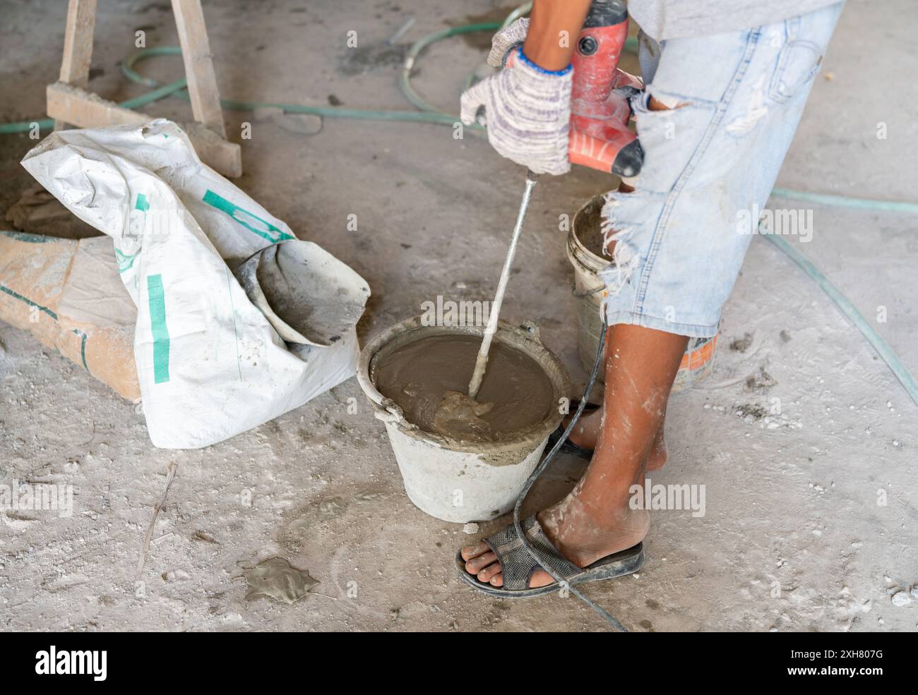 Worker mixing cement with a power drill in construction site Stock ...