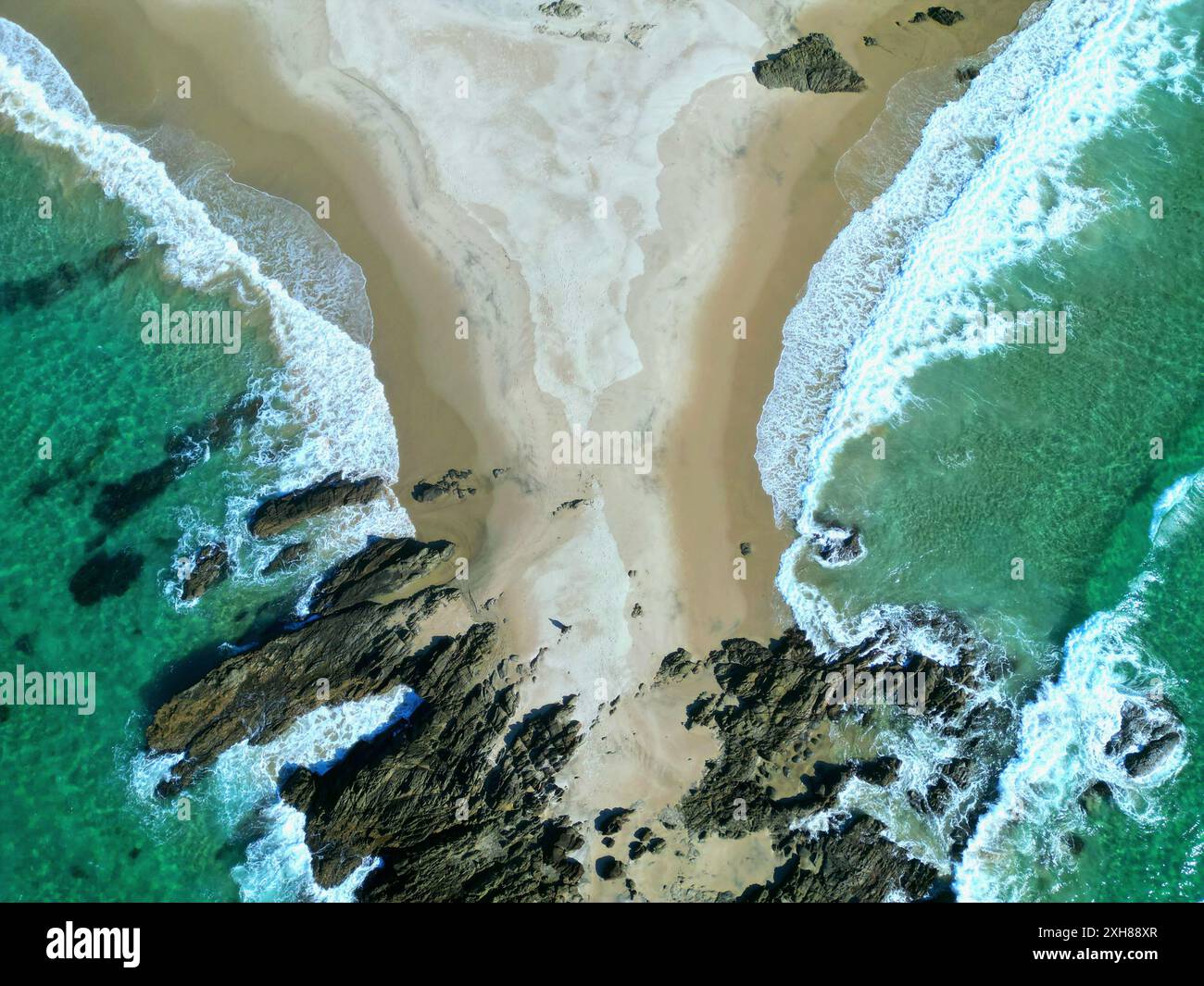 An aerial view of a beautiful beach with turquoise waters and rocks ...