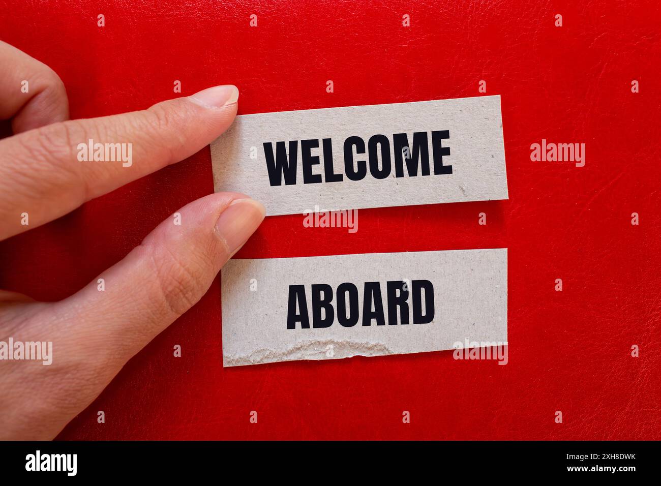 Welcome aboard message written on paper pieces with red background ...