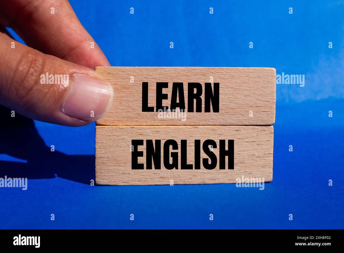 Learn english message written on wooden blocks with blue background. Conceptual learn english ...