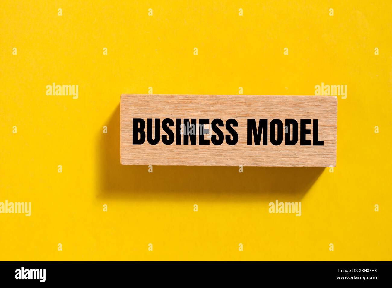 Business model message written on single wooden block with yellow ...
