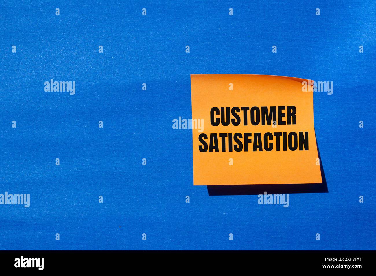Customer satisfaction message written on orange paper with blue ...