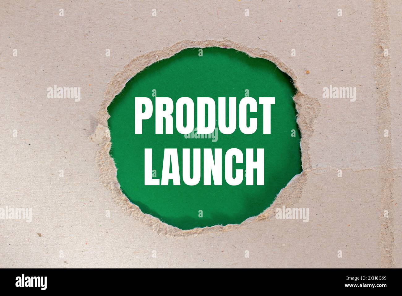 Product launch message written on ripped torn paper with green ...