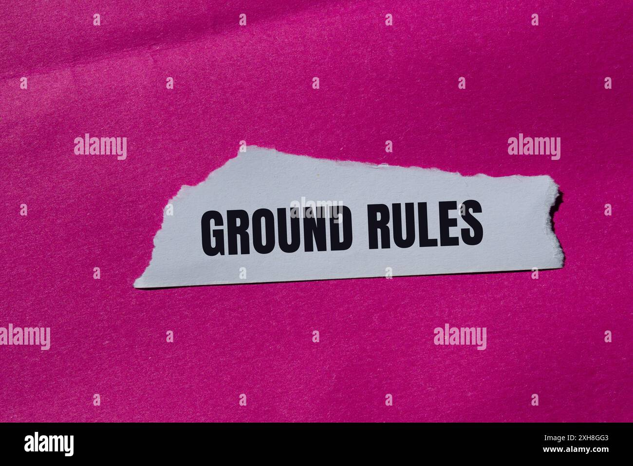 Ground rules message written on ripped white paper piece with pink ...