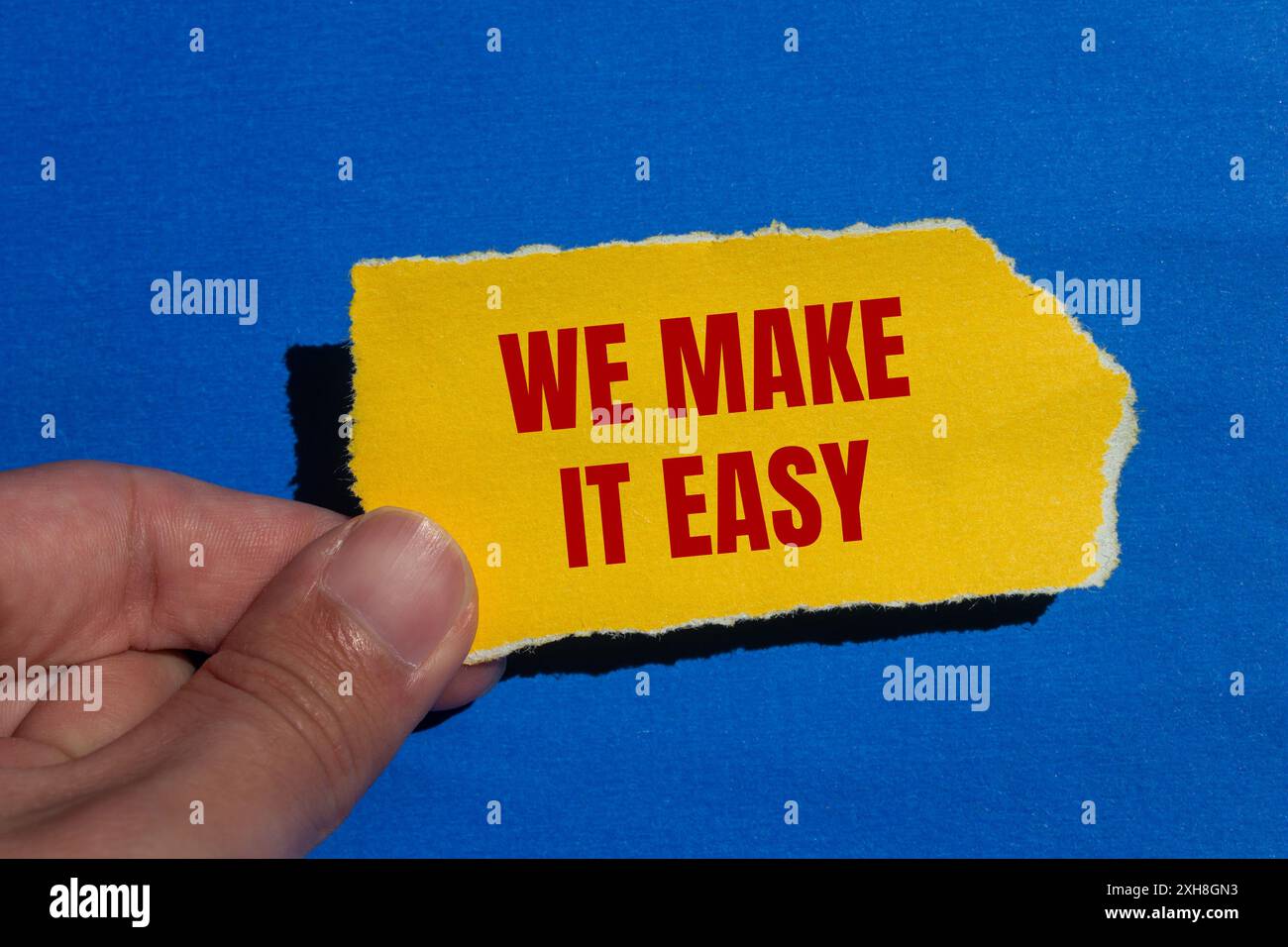 We make it easy message written on ripped torn yellow paper with blue ...