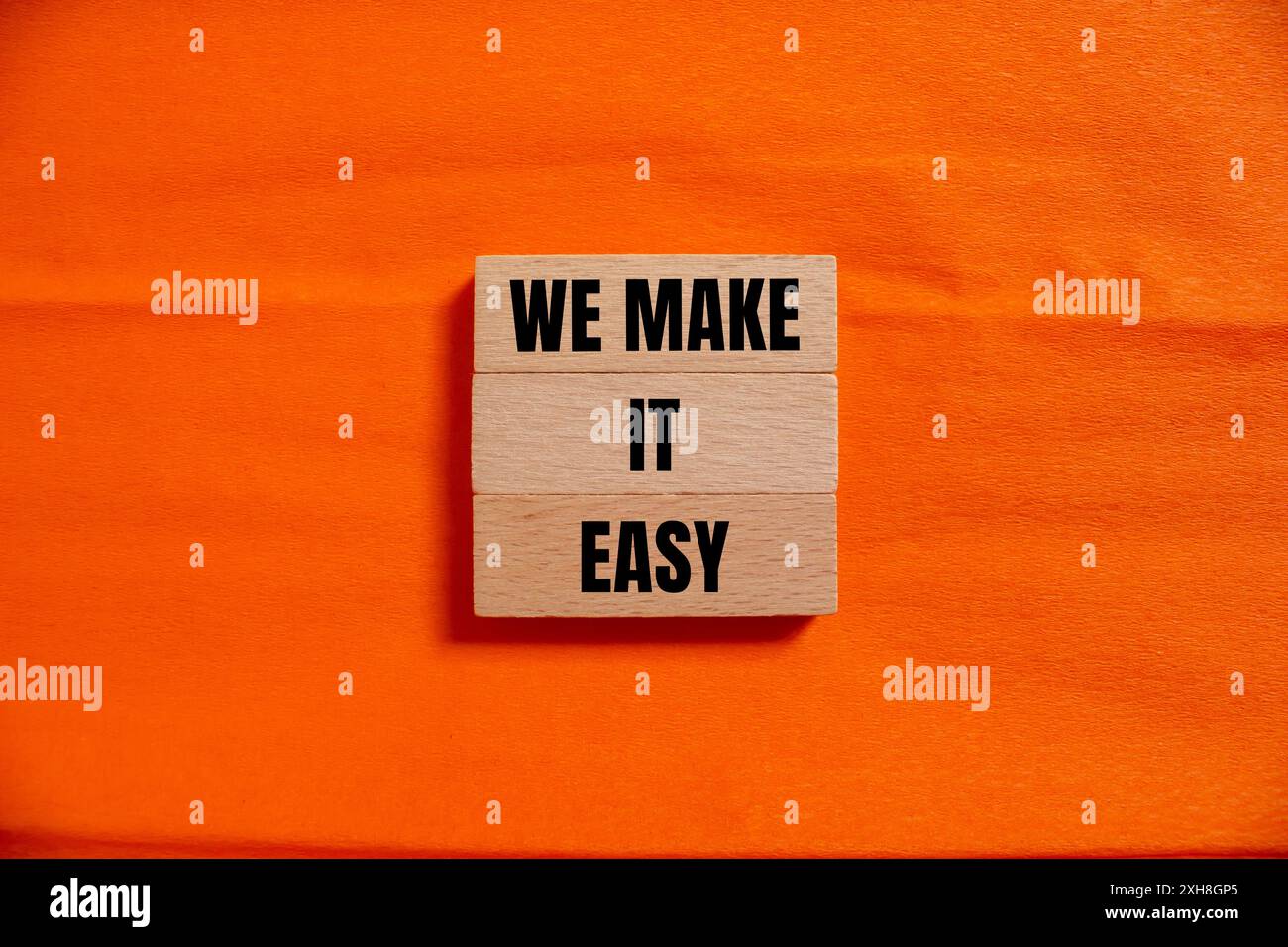 We make it easy message written on wooden blocks with orange background. Conceptual we make it ...