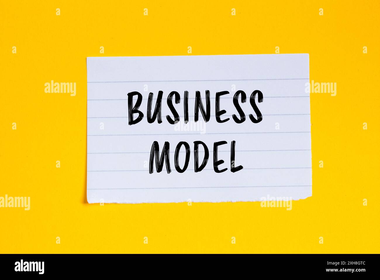 Business model message written on ripped white paper piece with yellow ...