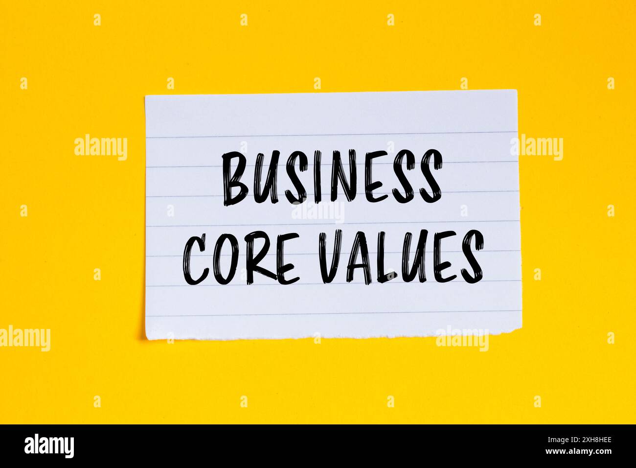 Business core values message written on ripped white paper piece with ...