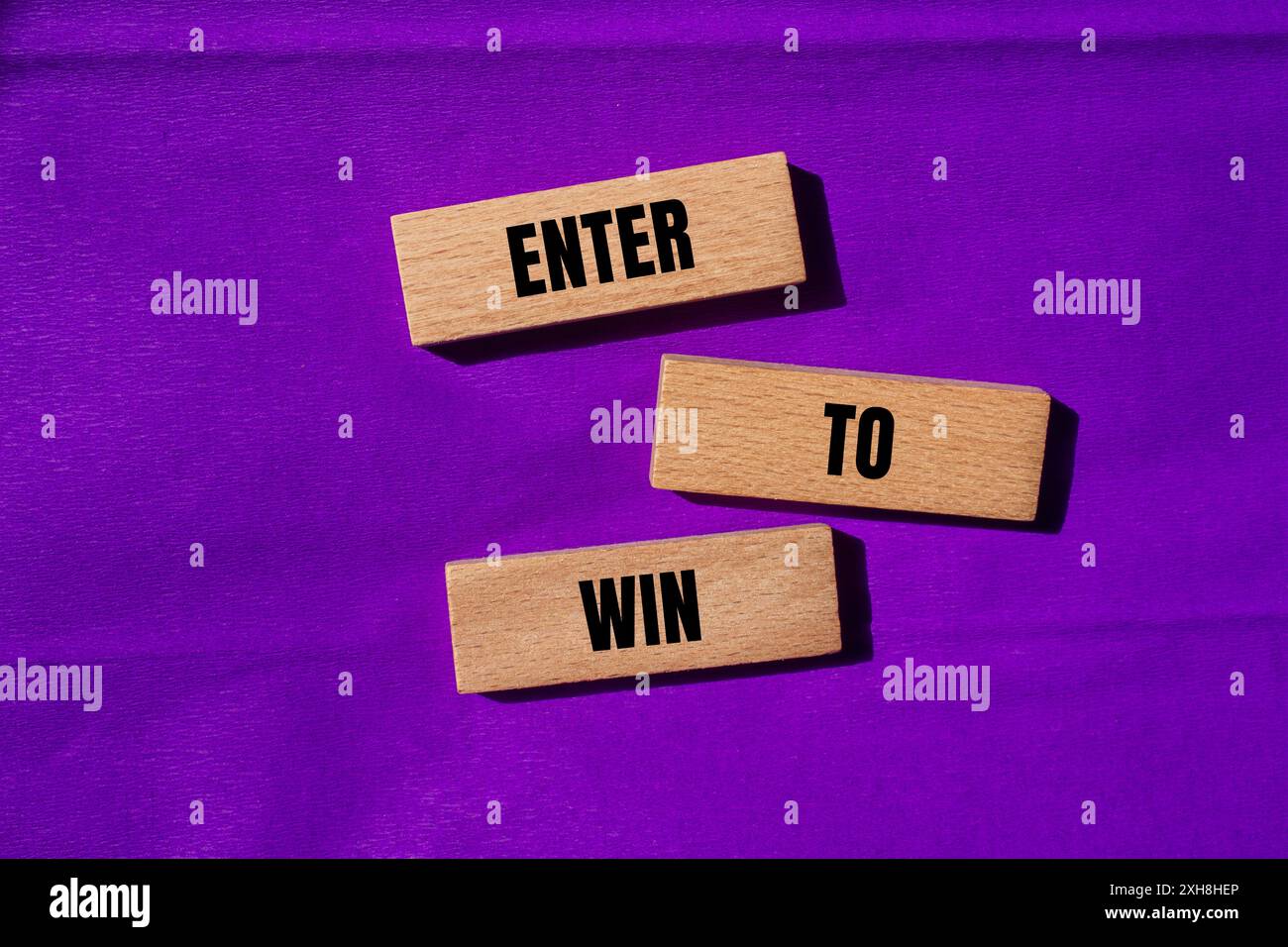 Enter to win message written on wodoen blocks with purple background ...