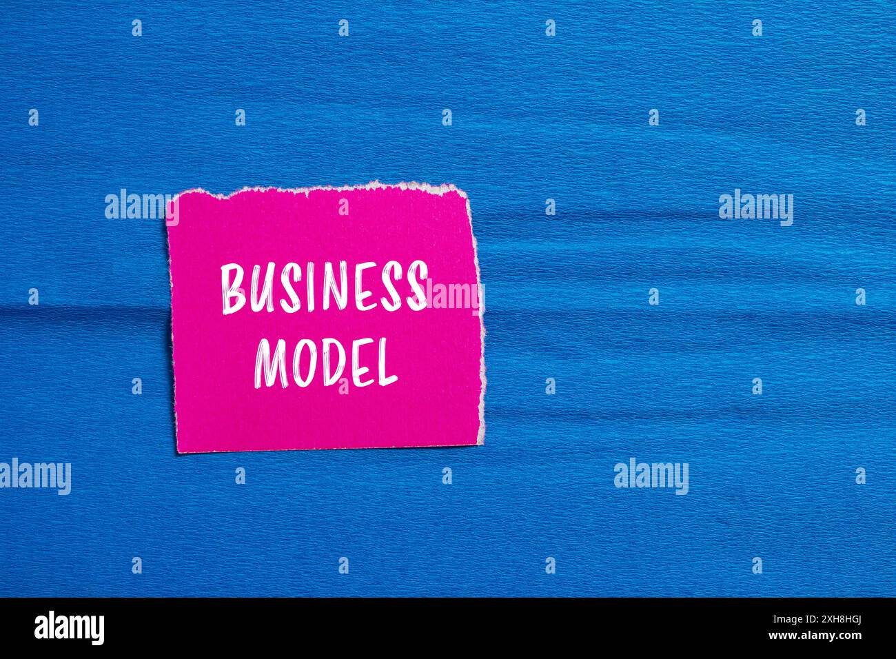 Business model message written on ripped torn pink paper piece with ...