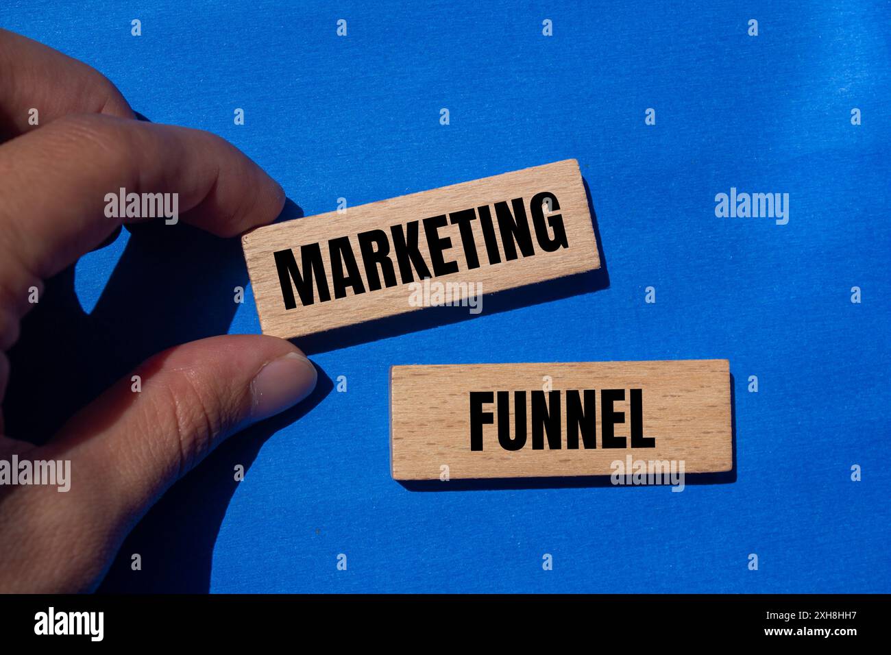 Marketing funnel message written on wooden blocks with blue background ...