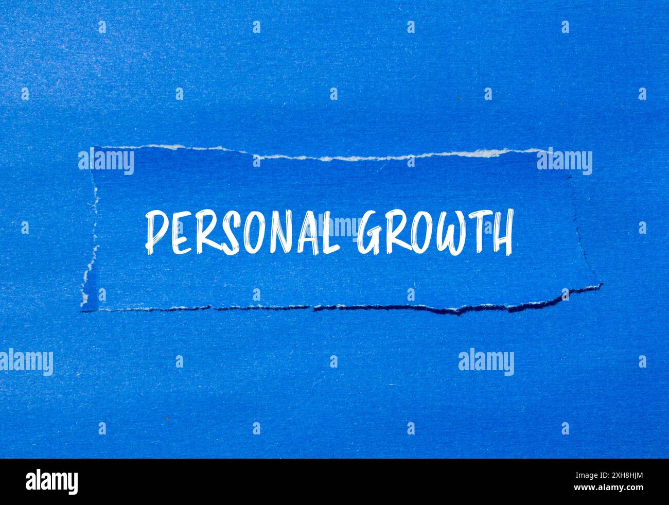 Personal growth message written on ripped paper piece with blue ...