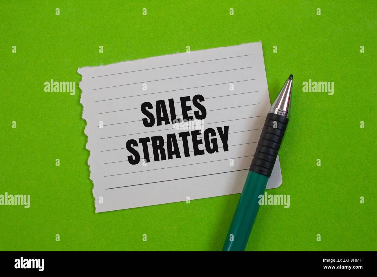 Sales strategy message written on ripped paper piece with ...