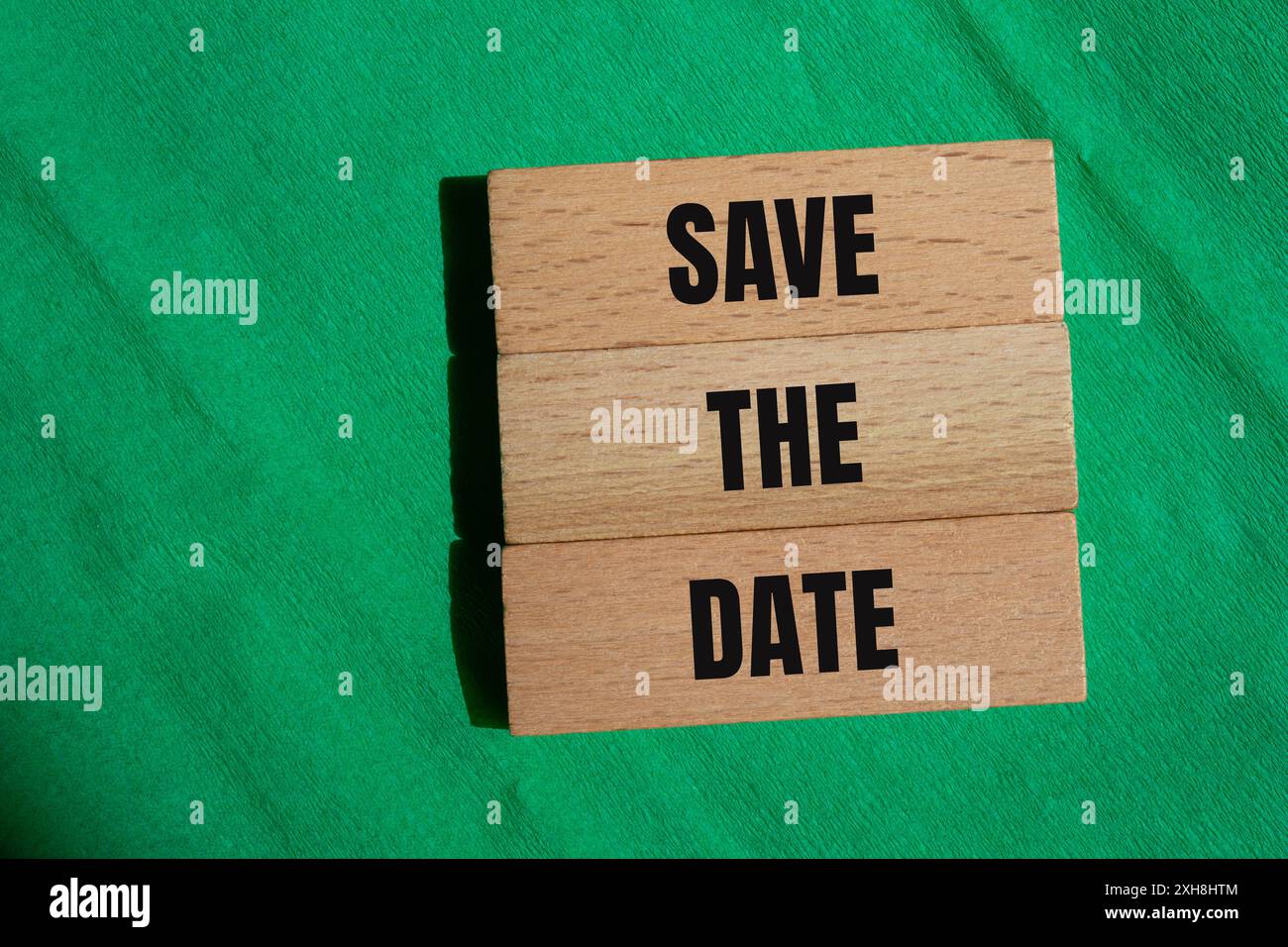 Save the date words written on wooden blocks with green background. Conceptual save the date ...