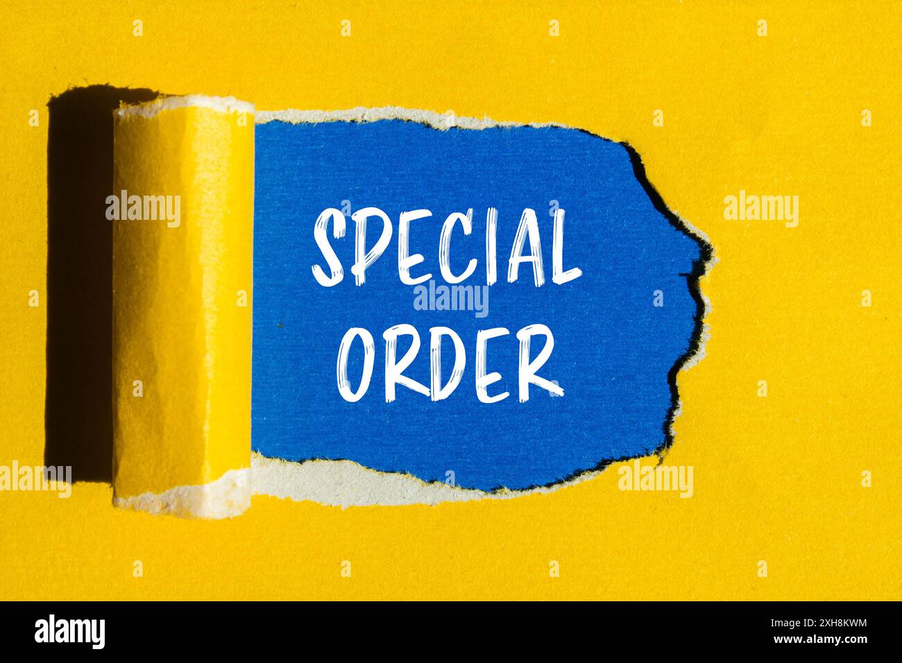 Special order message written on ripped yellow paper with blue ...