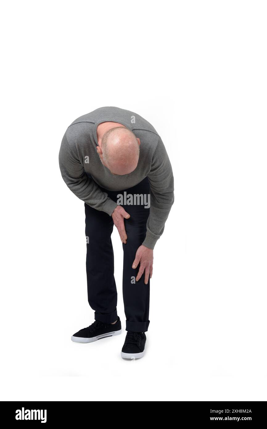 man crouching with leg pain on white background Stock Photo - Alamy