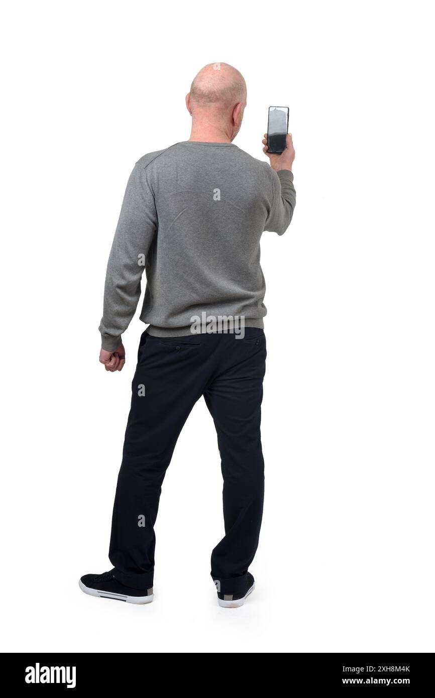 rear view of a serious man taking a self-portrait with smartphone on ...