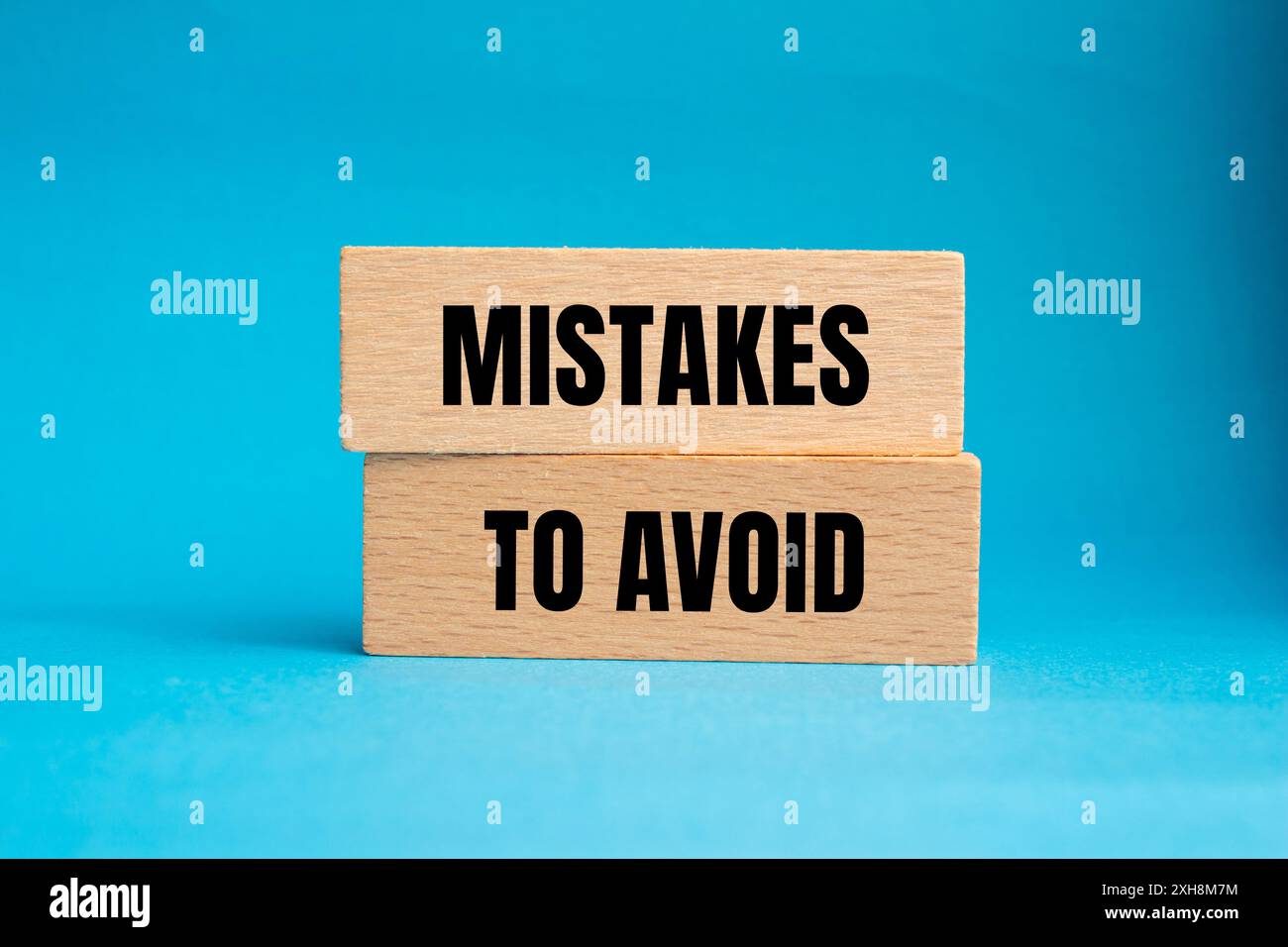 Mistakes to avoid message written on wooden blocks with blue background ...