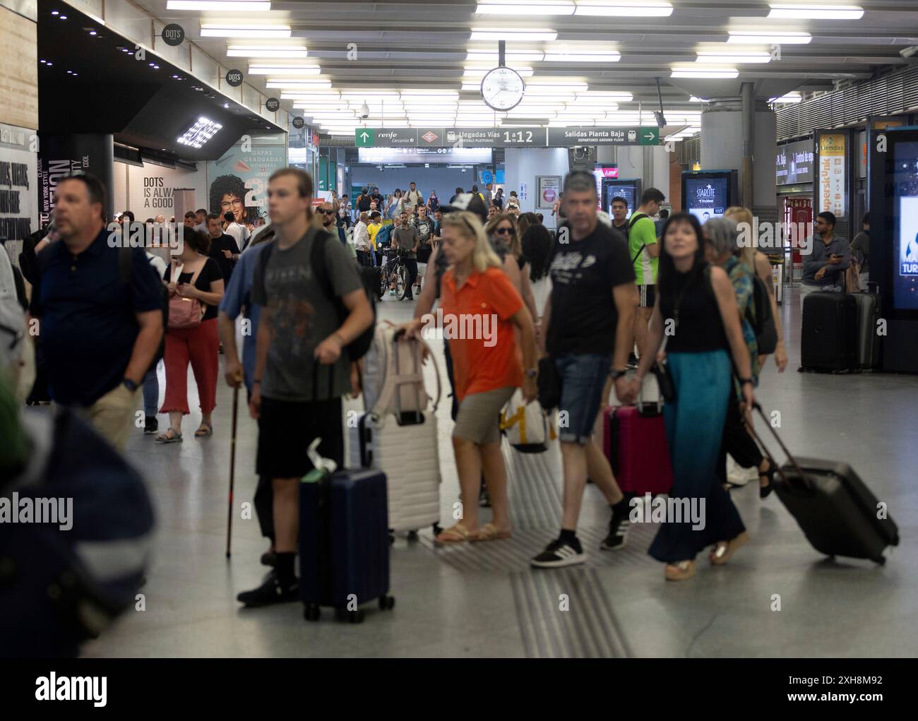 Several people queue with suitcases at the Puerta de Atocha-Almudena ...