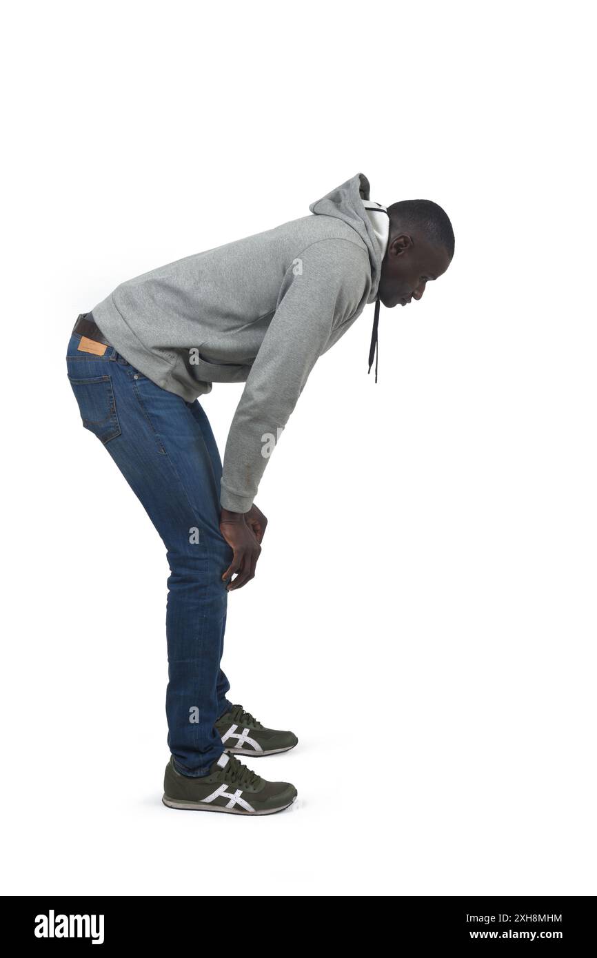 Side view portrait of a crouching man looking down on white background ...
