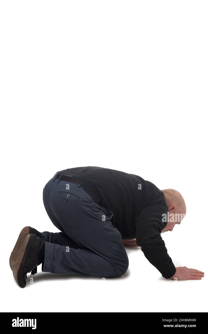 side view of a man on his knees staring at the ground on white ...