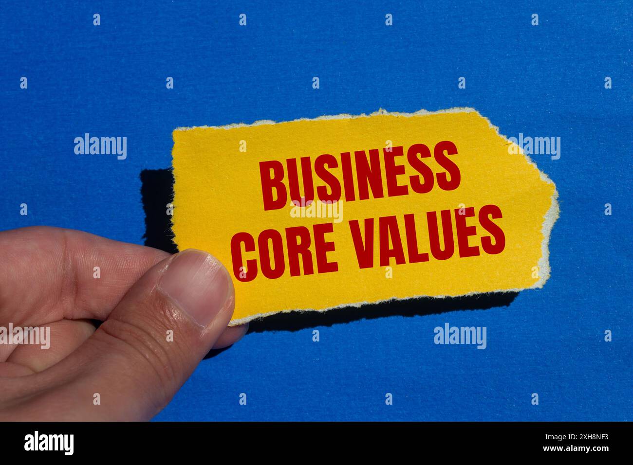 Business core values message written on ripped torn yellow paper with ...